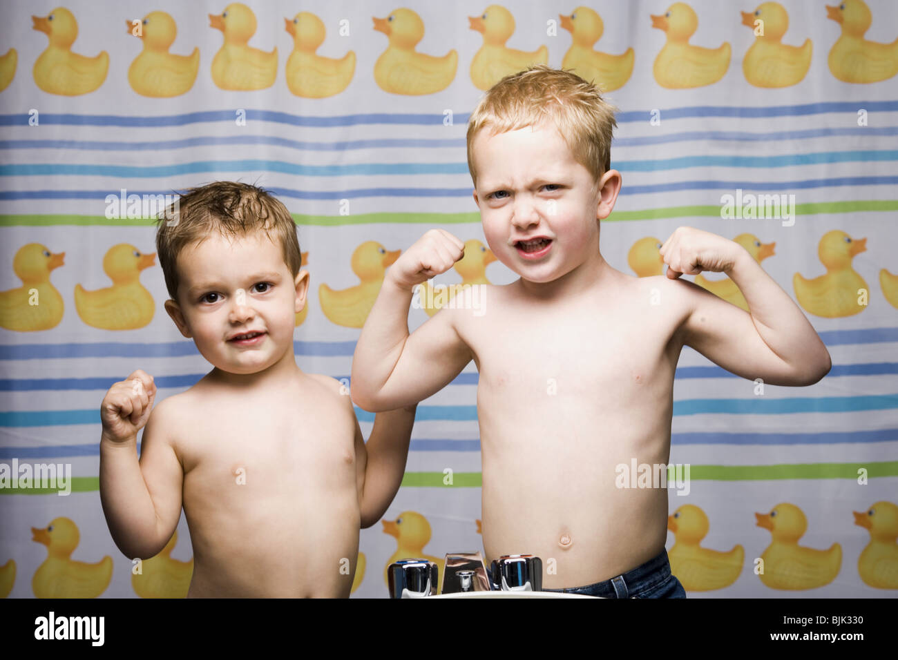 Two boys flexing muscles in bathroom Stock Photo - Alamy