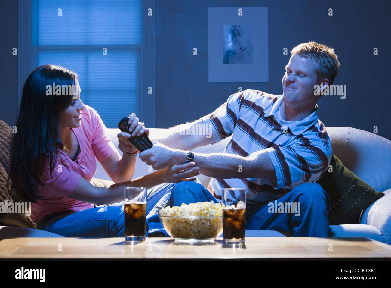 Couple fighting over television remote Stock Photo - Alamy