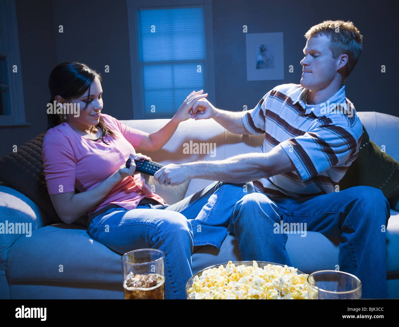 Couple fighting over television remote Stock Photo - Alamy