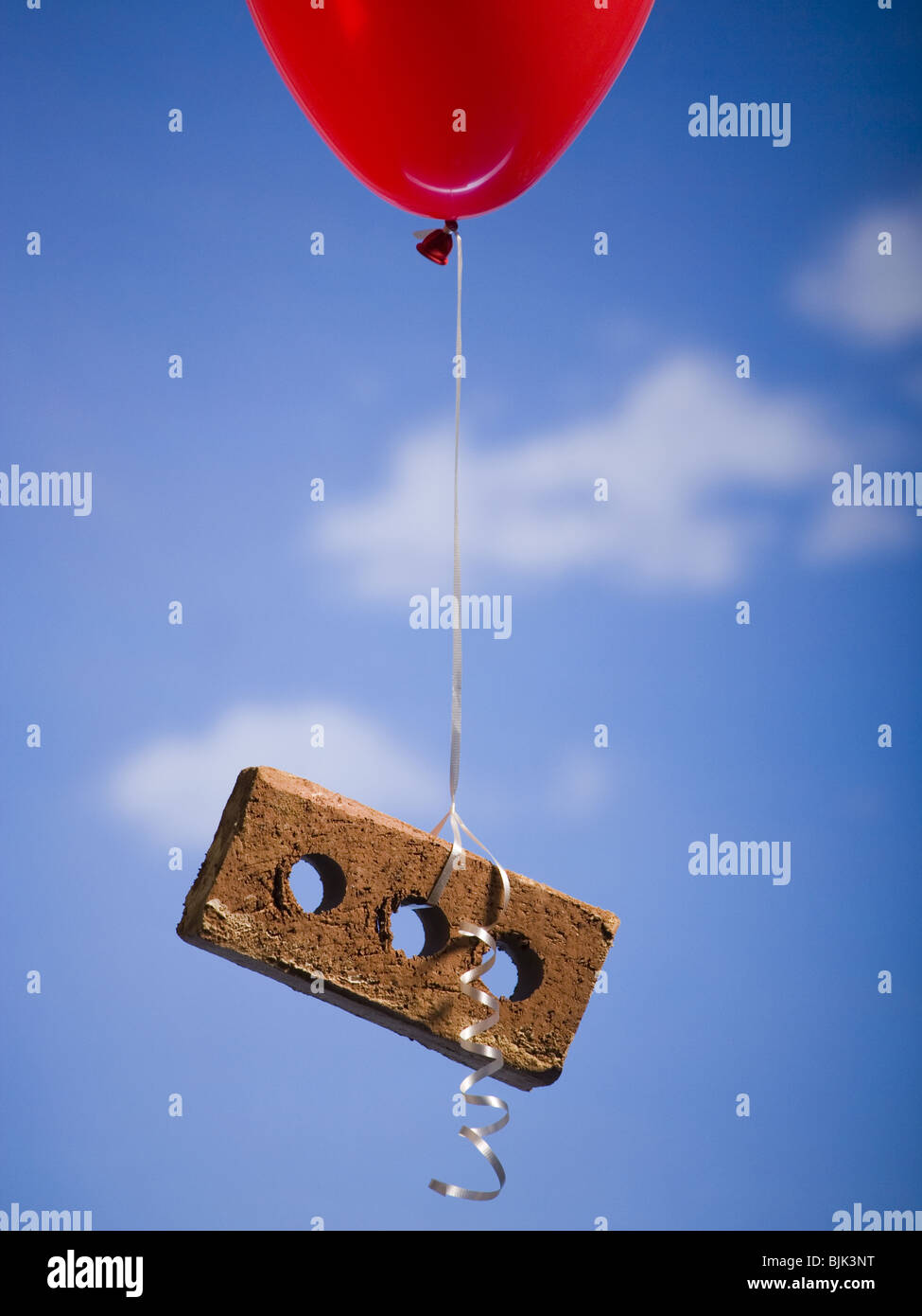 Helium balloon lifting brick outdoors Stock Photo - Alamy
