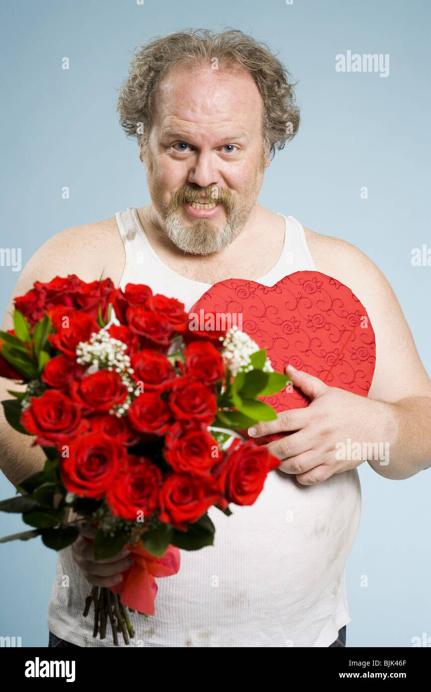 Disheveled man with red roses and heart box smiling Stock Photo - Alamy
