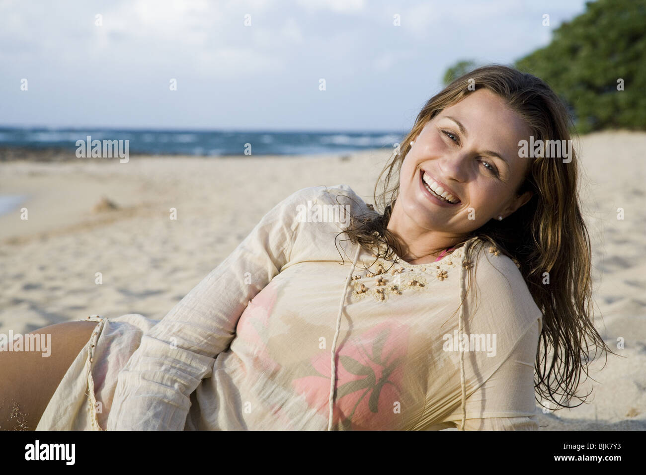 Woman on beach smiling Stock Photo - Alamy