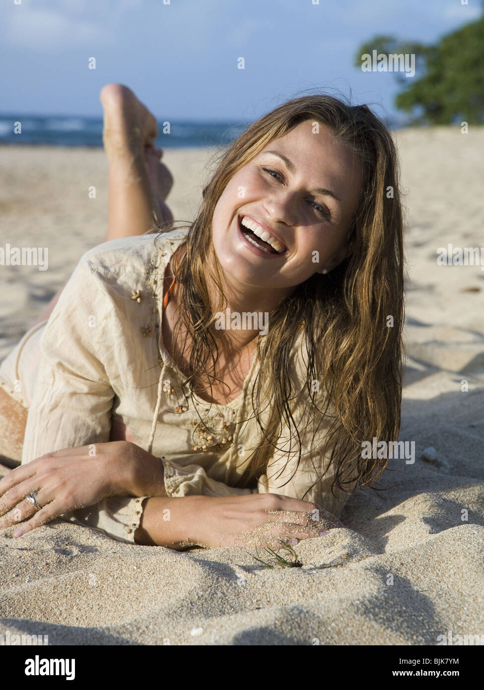 Woman on beach laughing Stock Photo - Alamy