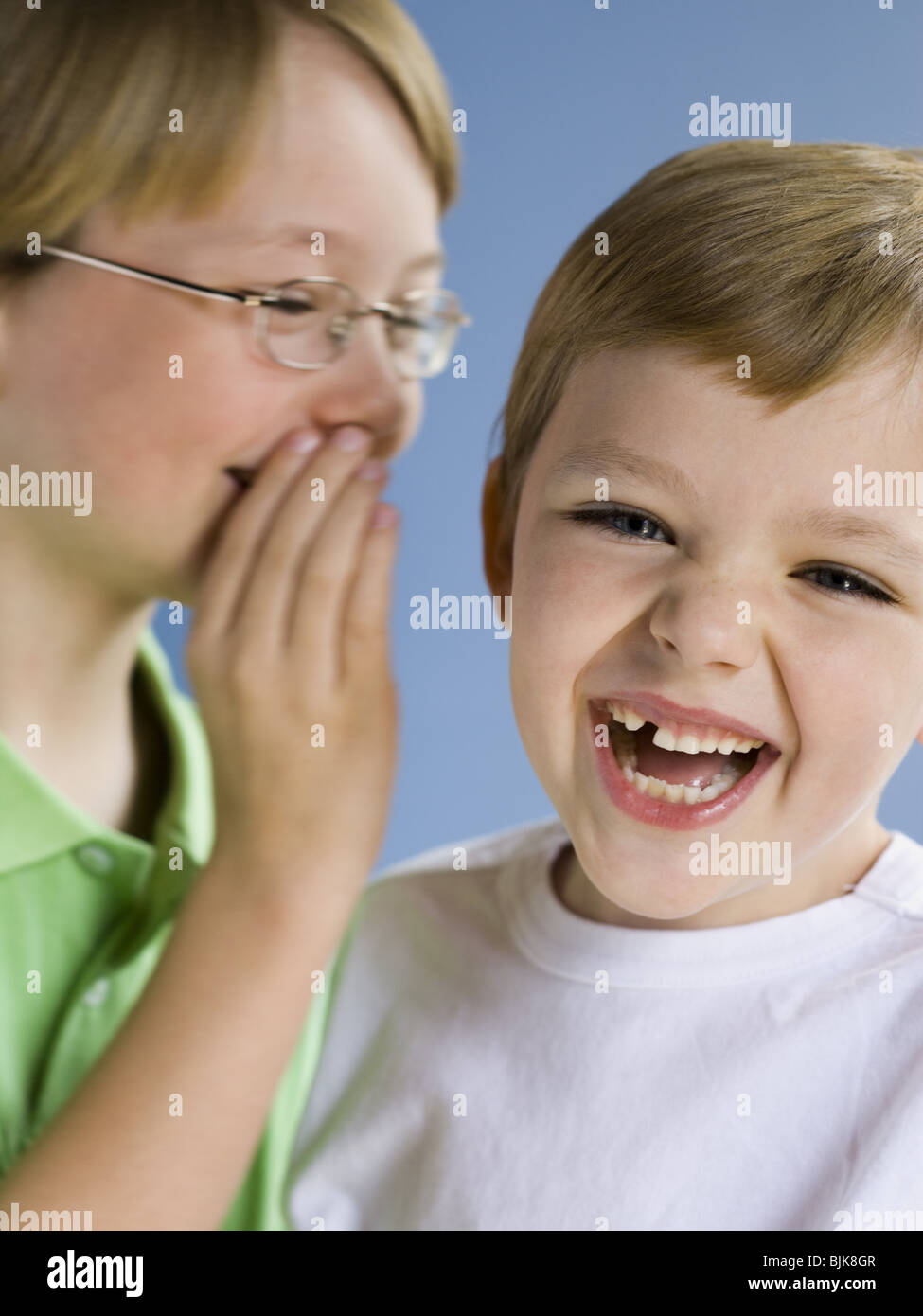 Boy whispering to smiling boy Stock Photo - Alamy