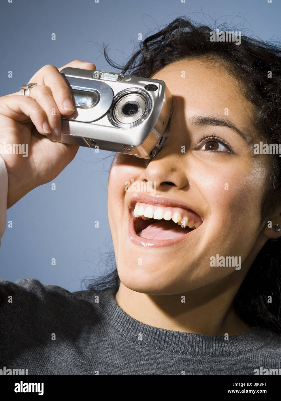 Woman taking a photo with digital camera smiling Stock Photo - Alamy