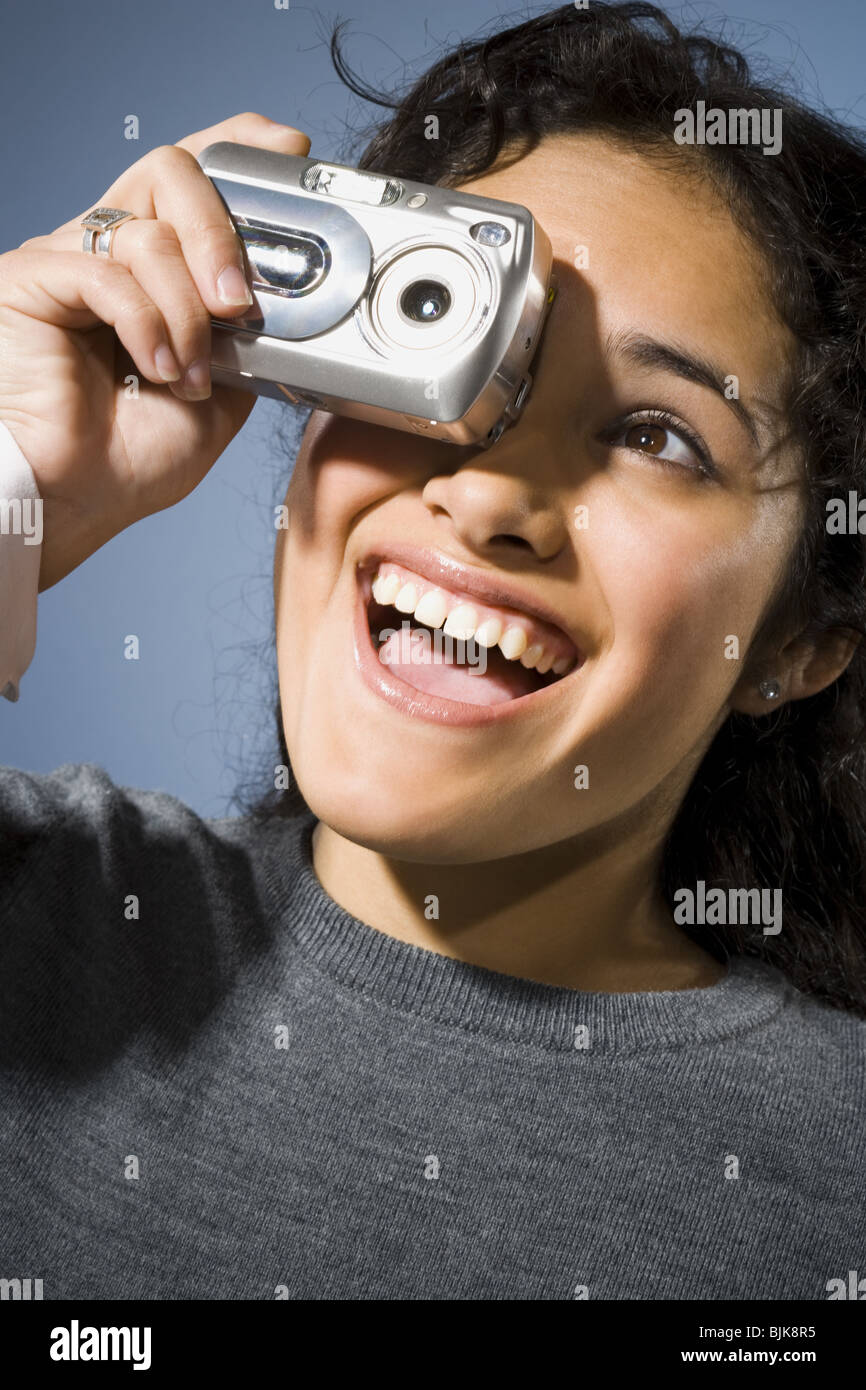 Woman taking a photo with digital camera smiling Stock Photo - Alamy