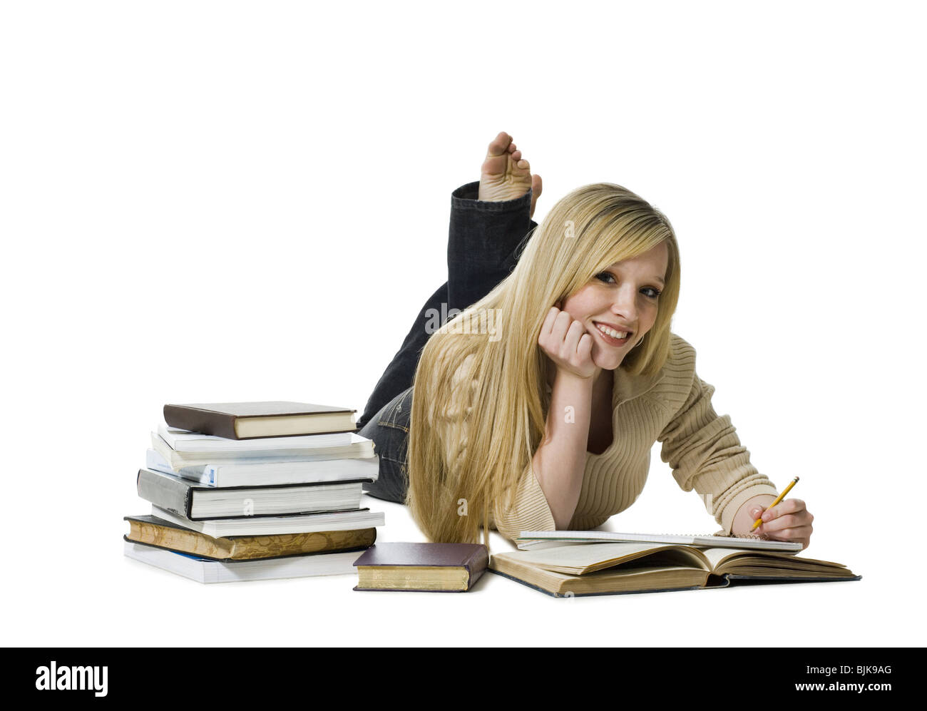Girl sitting cross legged doing homework smiling Stock Photo - Alamy