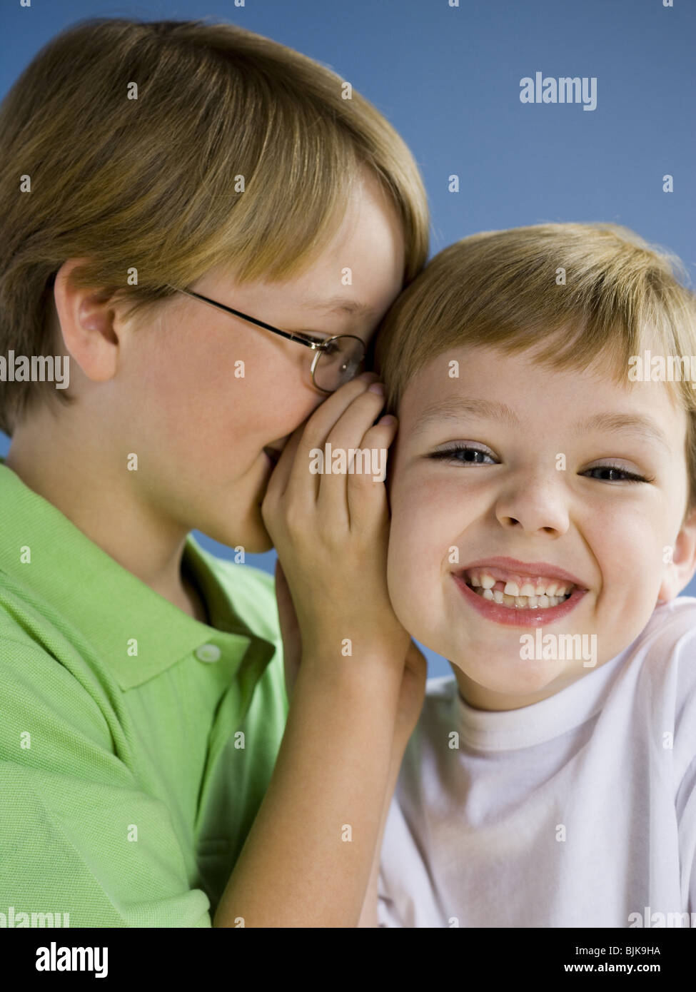 Boy whispering and smiling Stock Photo - Alamy