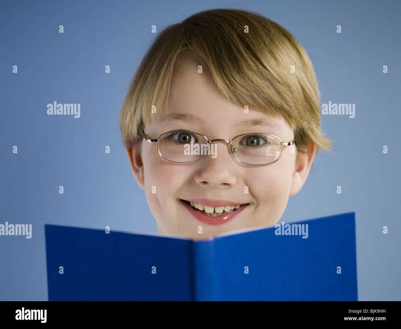 Boy reading book and smiling Stock Photo - Alamy