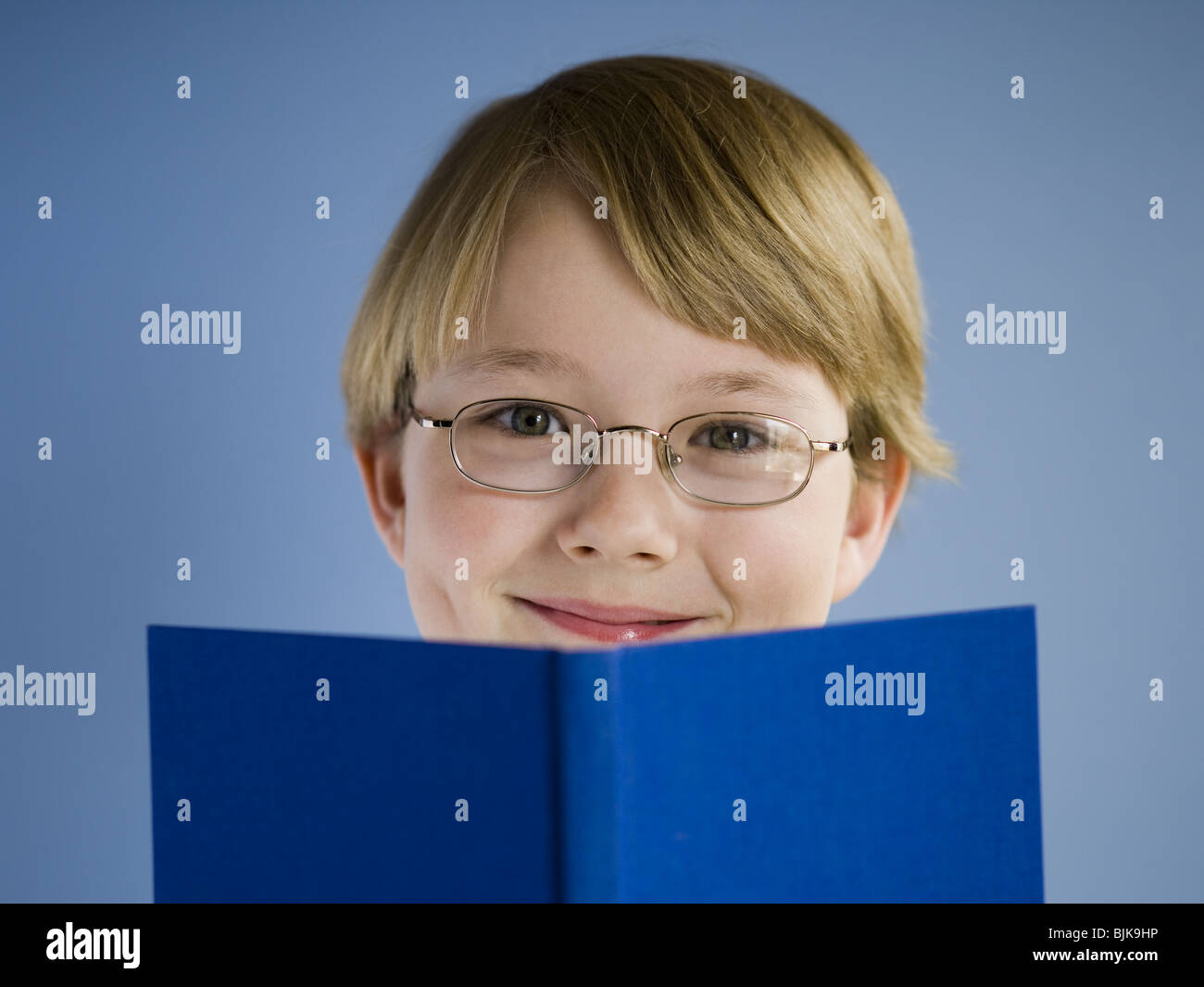Boy reading book and smiling Stock Photo - Alamy