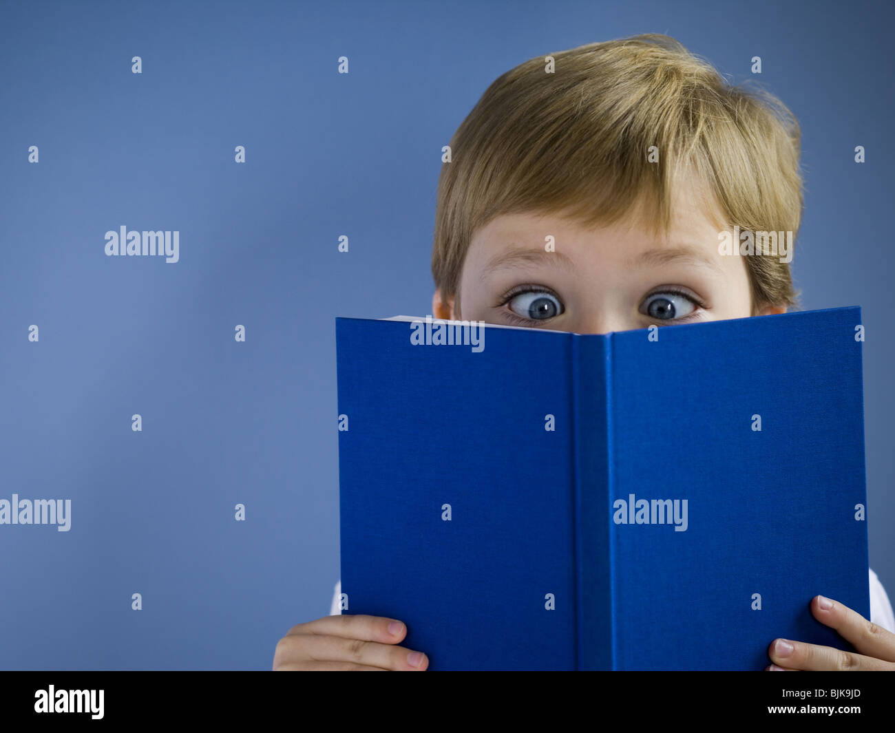 Boy reading book and smiling Stock Photo - Alamy