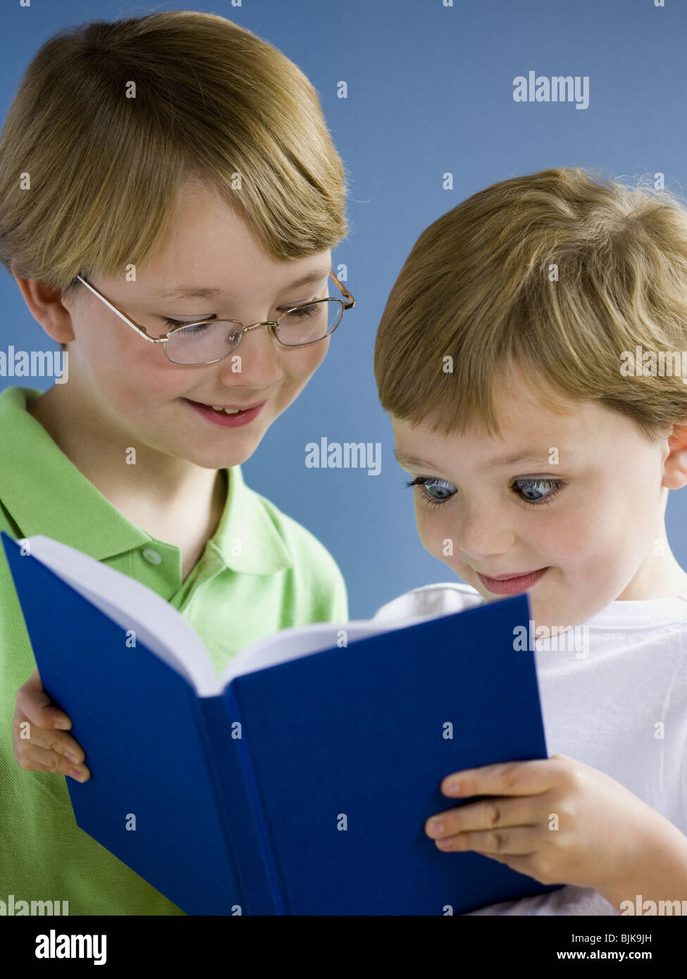 Two boys reading book Stock Photo - Alamy