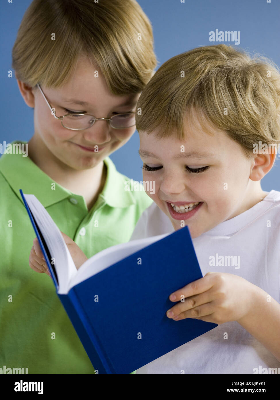 Two boys reading book Stock Photo - Alamy