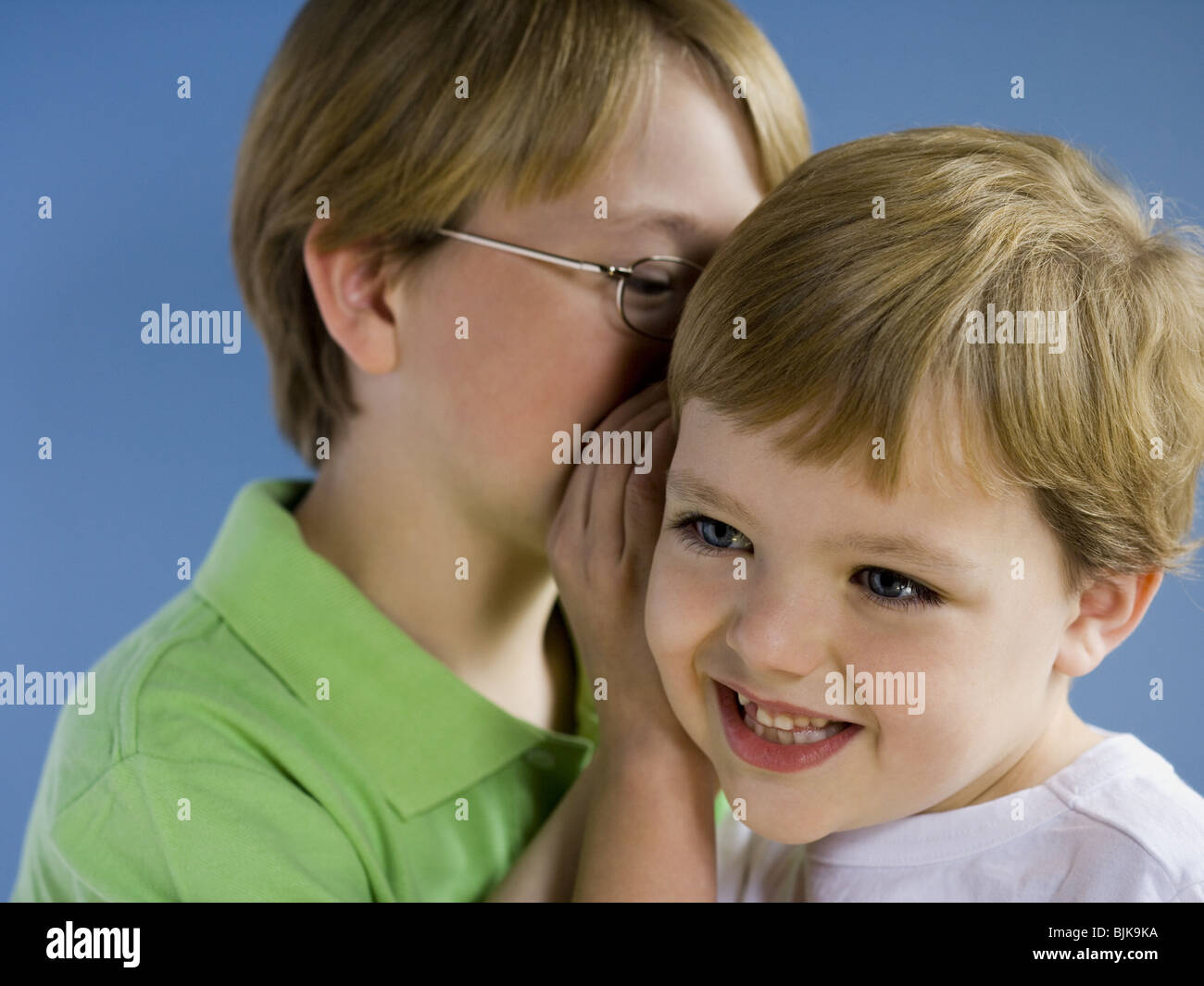 Boy whispering and smiling Stock Photo - Alamy