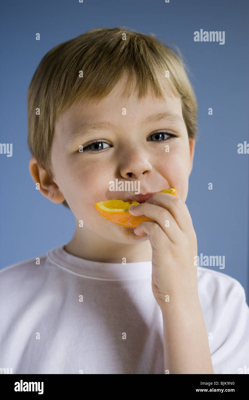 Boy eating wedge of orange hi-res stock photography and images - Alamy