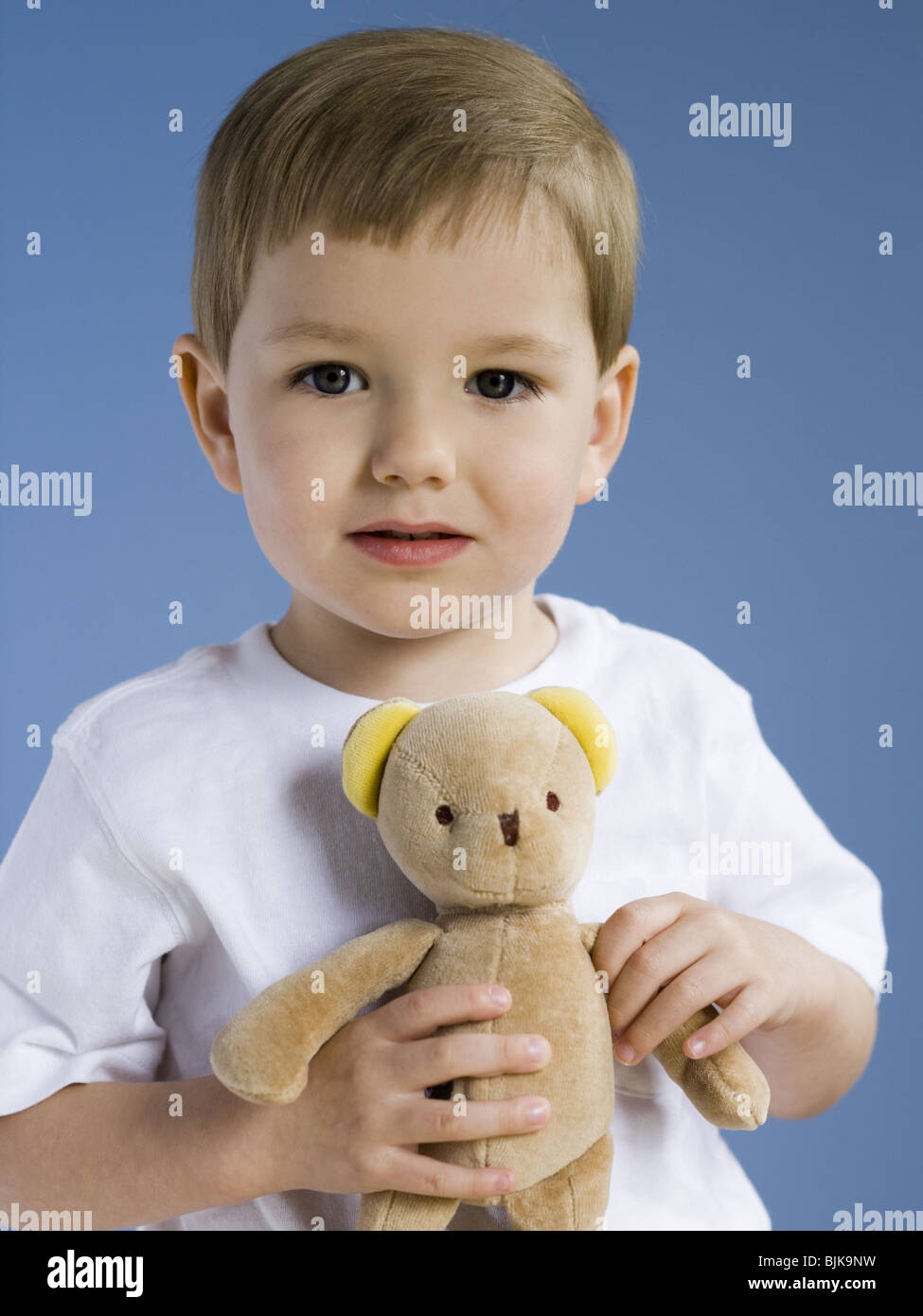 Boy holding teddy bear smiling Stock Photo - Alamy