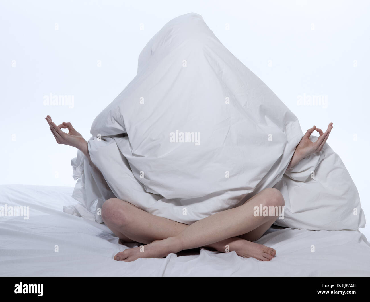 young woman in a white sheet bed on white background Stock Photo - Alamy