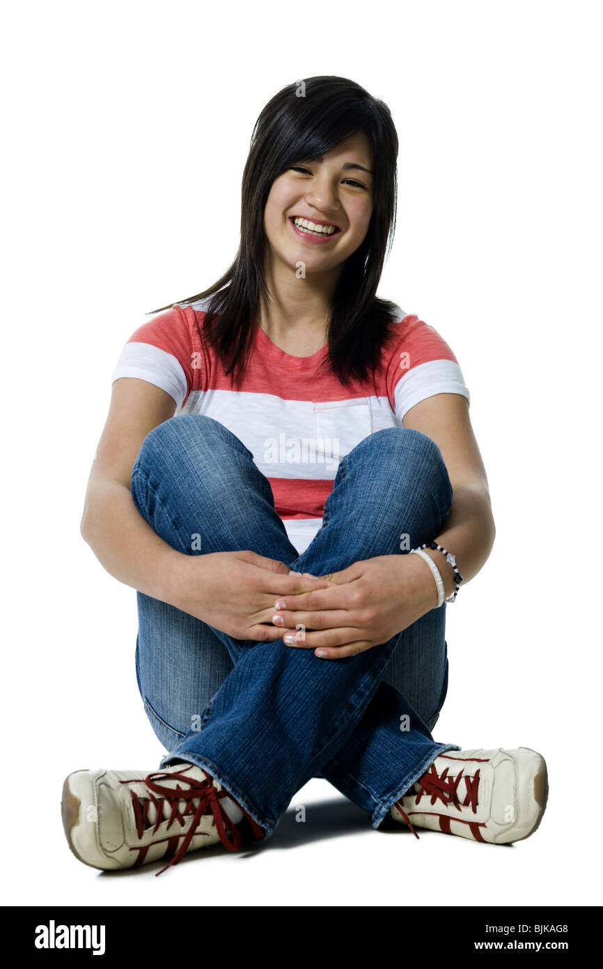 Girl sitting cross legged smiling Stock Photo - Alamy