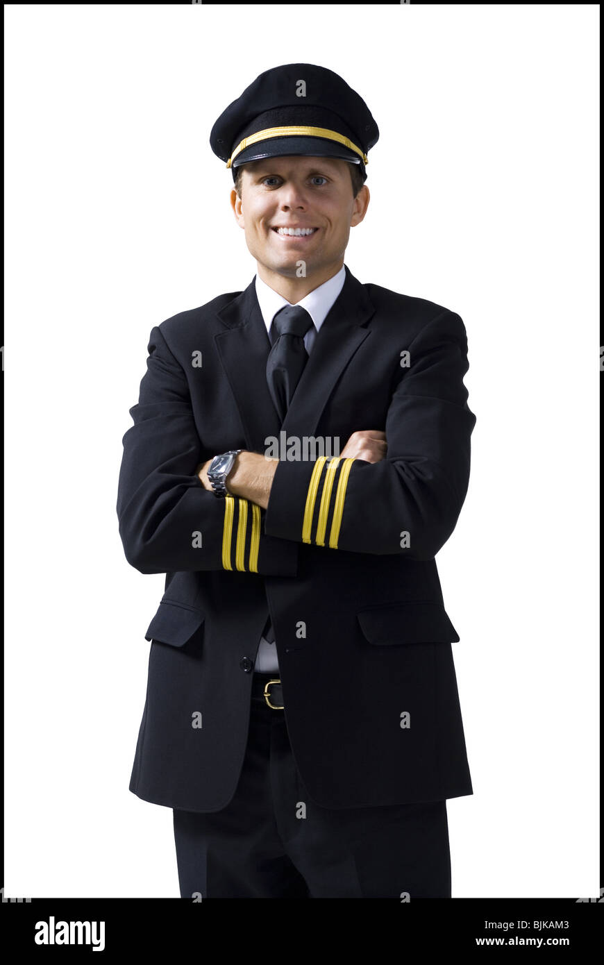 Pilot standing with arms crossed smiling Stock Photo - Alamy