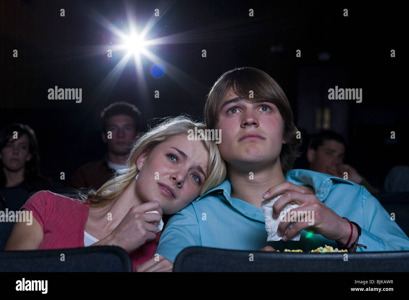 Boy and girl with tissues crying at movie theater Stock Photo - Alamy