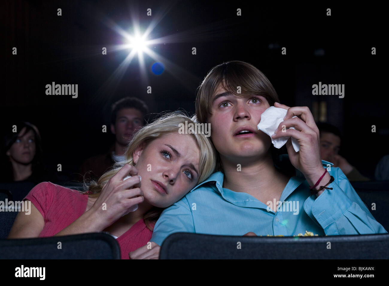 Boy and girl with tissues crying at movie theater Stock Photo - Alamy