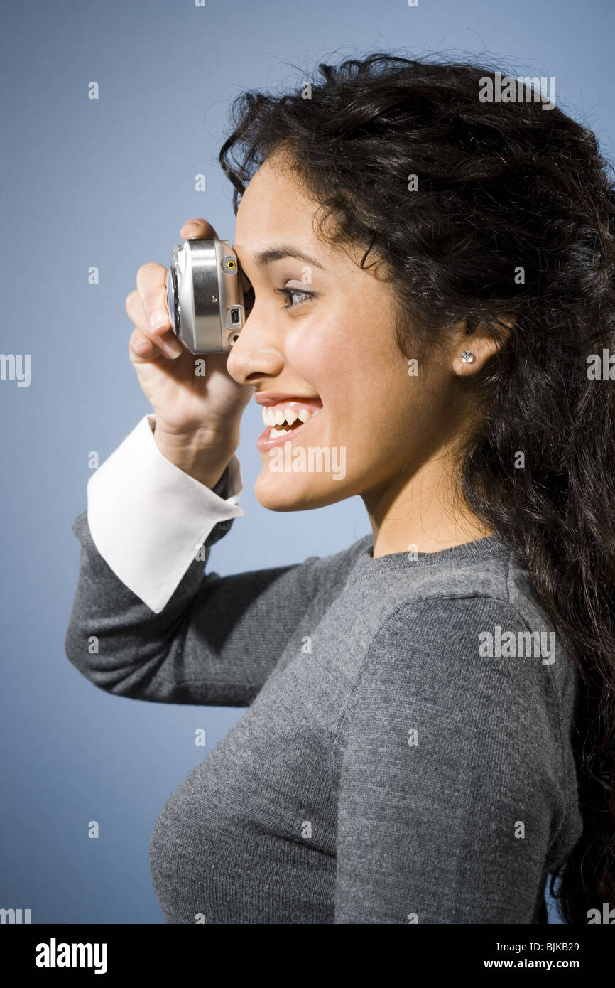Profile of woman taking a photo with digital camera smiling Stock Photo ...