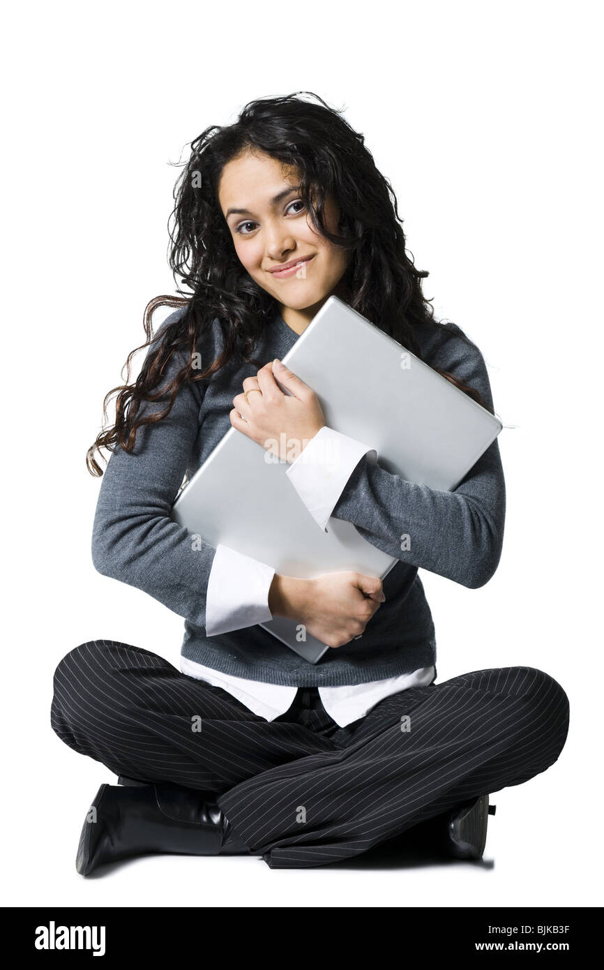 Woman sitting cross legged hugging laptop Stock Photo - Alamy