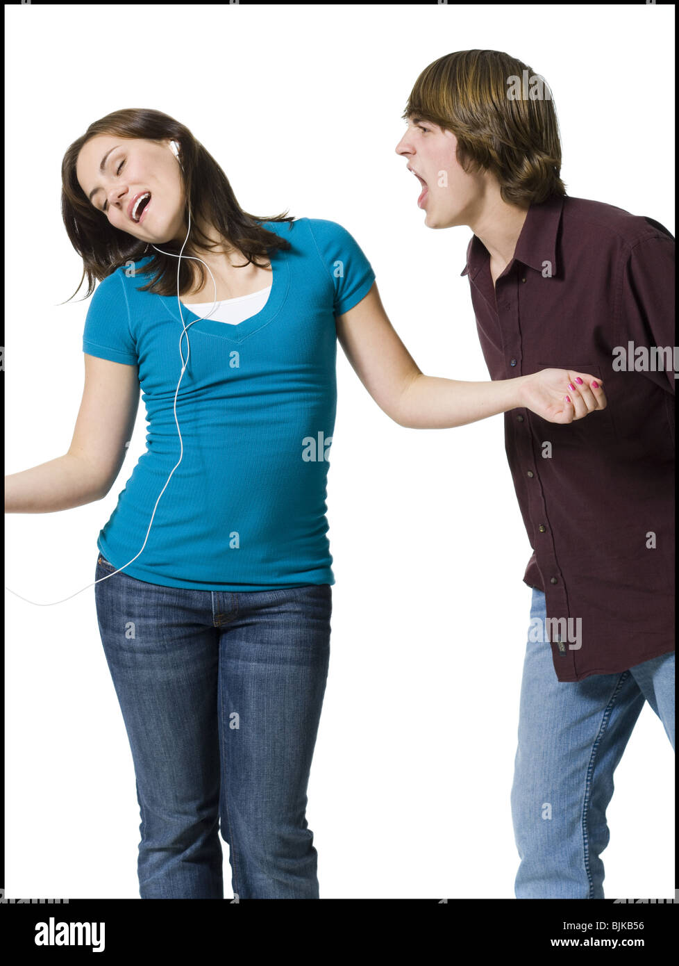 Girl listening to mp3 player with boy yelling Stock Photo - Alamy