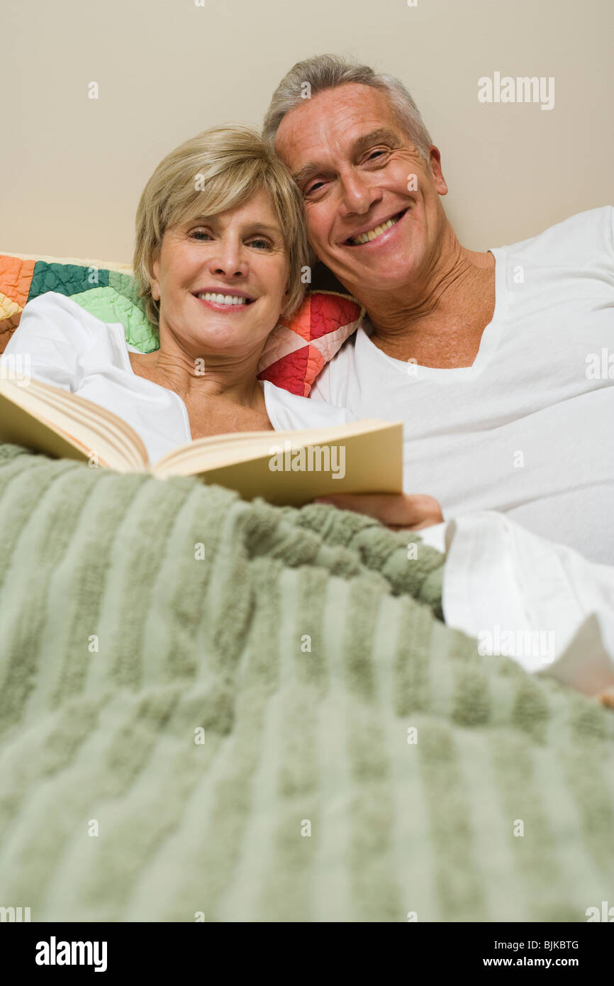 Couple in bed snuggling reading hi-res stock photography and images - Alamy