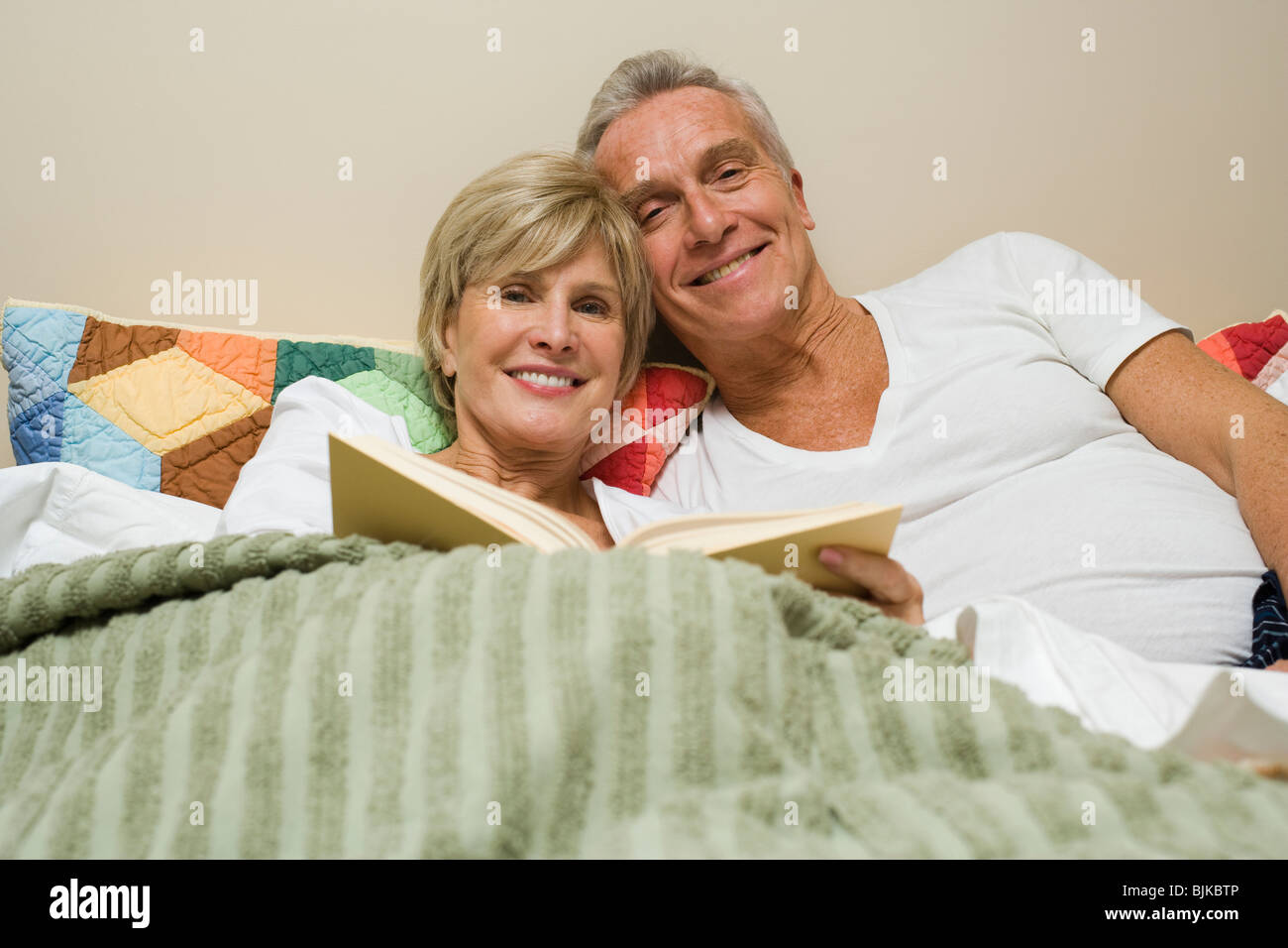 Mature couple in bed reading Stock Photo - Alamy