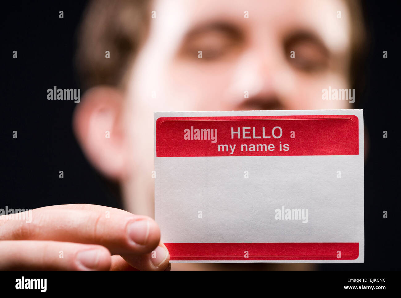Man holding blank name tag Stock Photo - Alamy