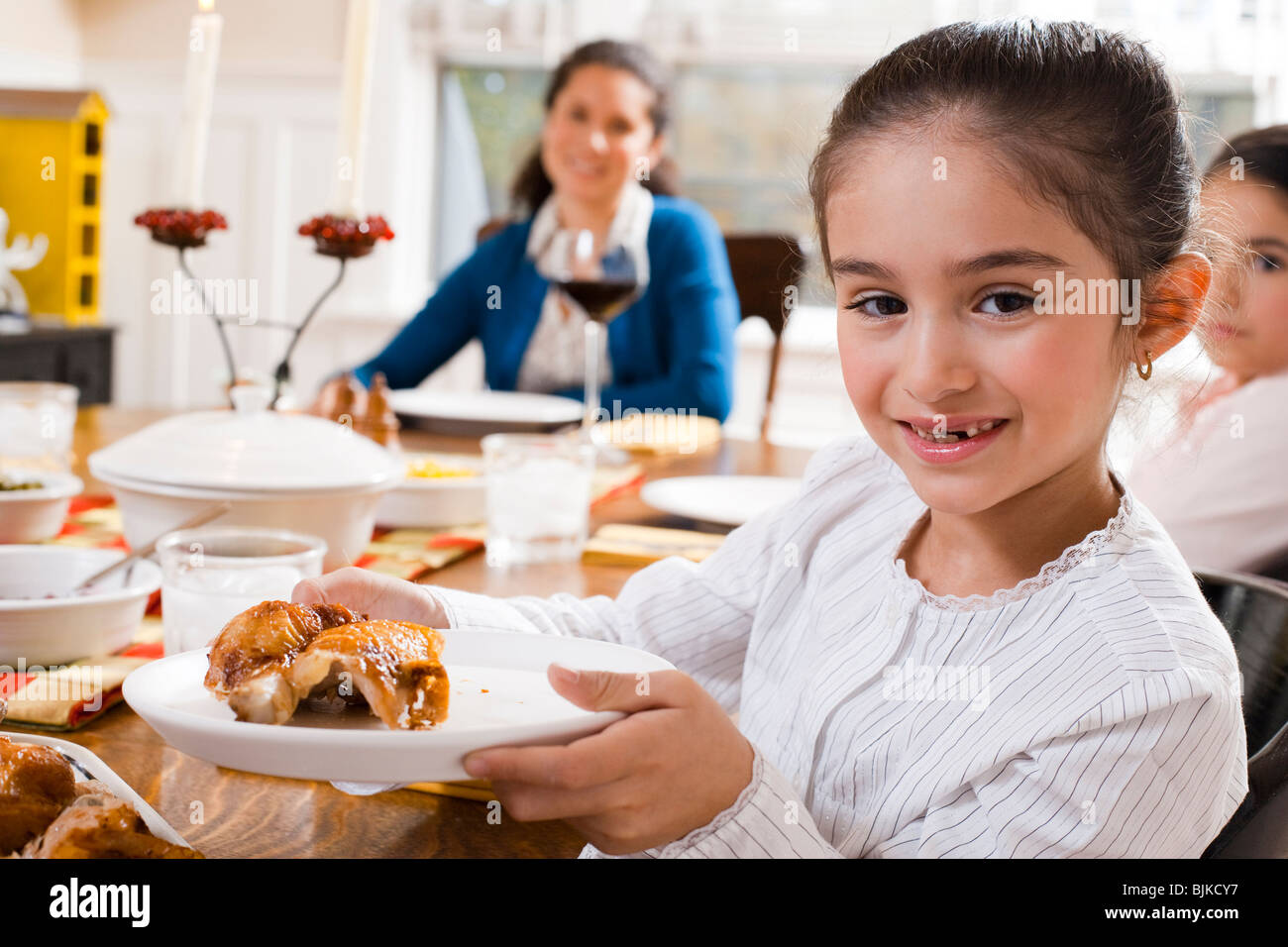 Girl at dinner table with woman smiling Stock Photo - Alamy
