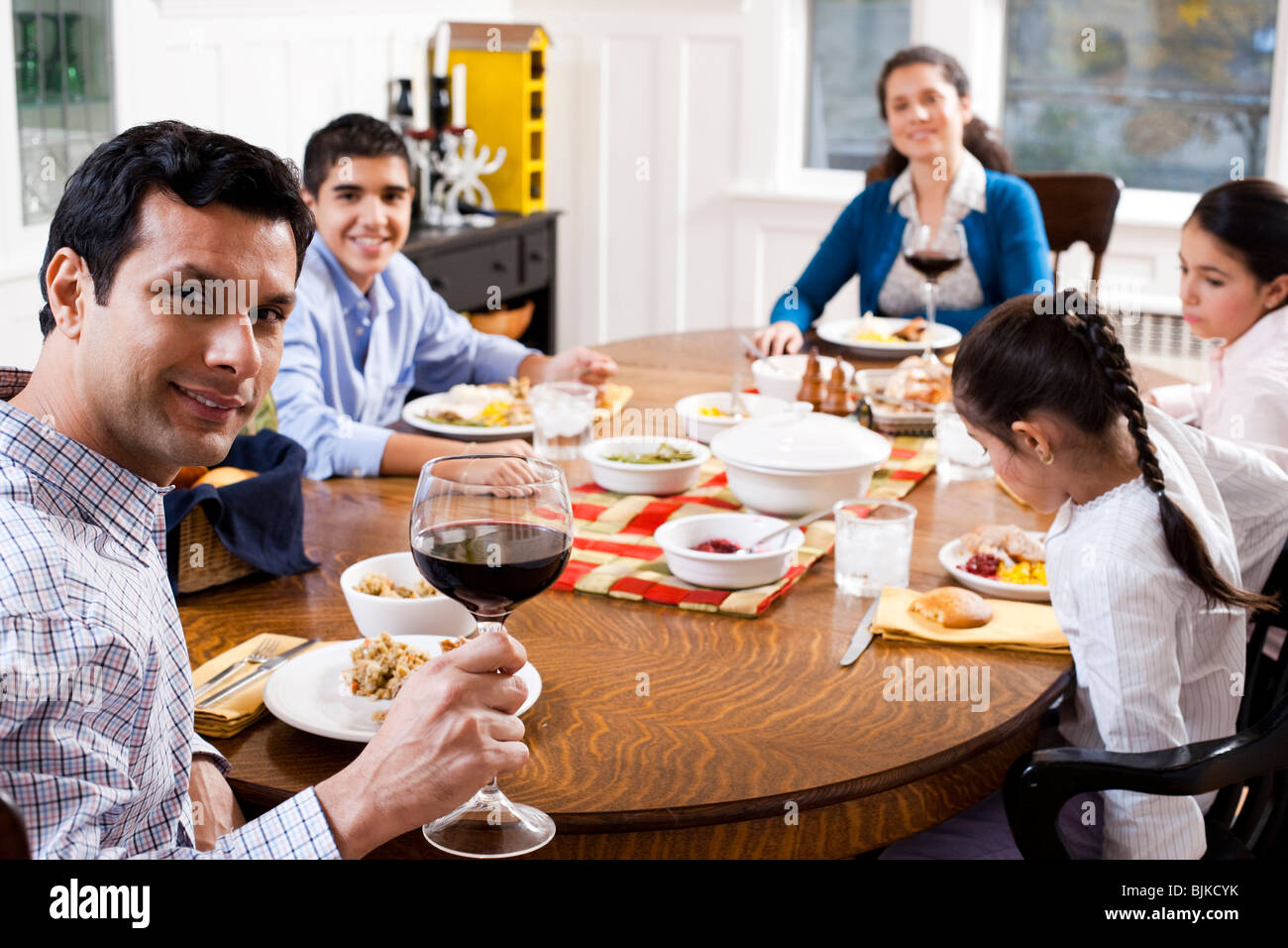 Family at dinner table smiling Stock Photo - Alamy