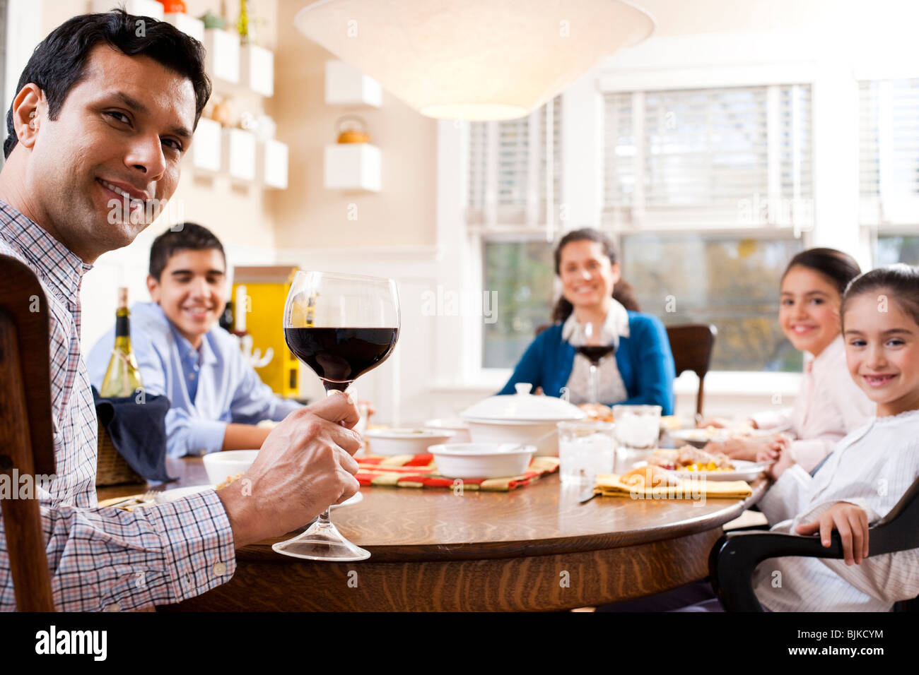 Family at dinner table smiling Stock Photo - Alamy