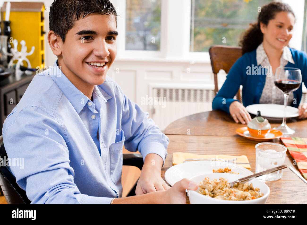 Family at dinner table smiling Stock Photo - Alamy