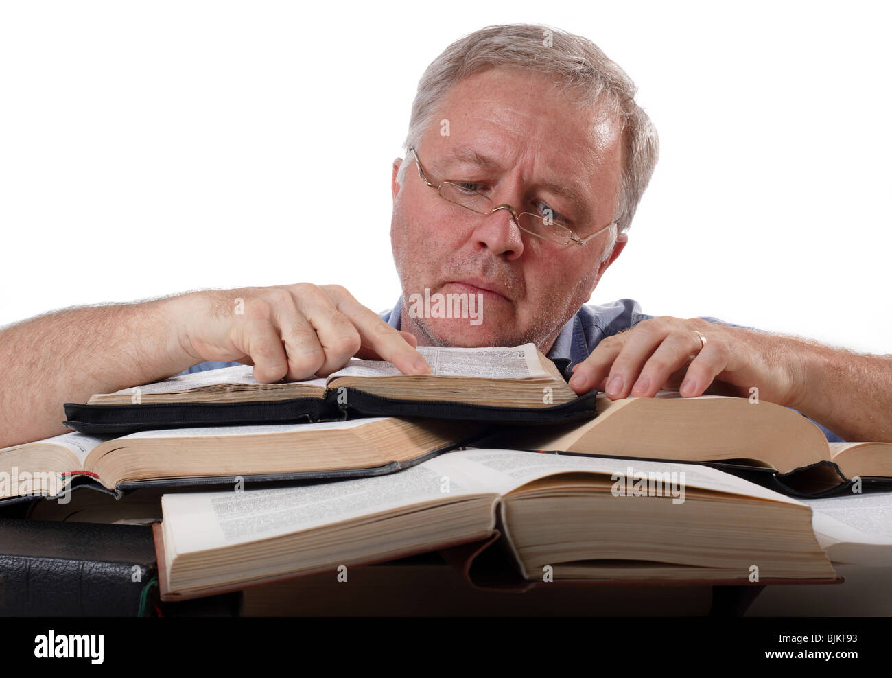 Man with glasses working with many books Stock Photo - Alamy
