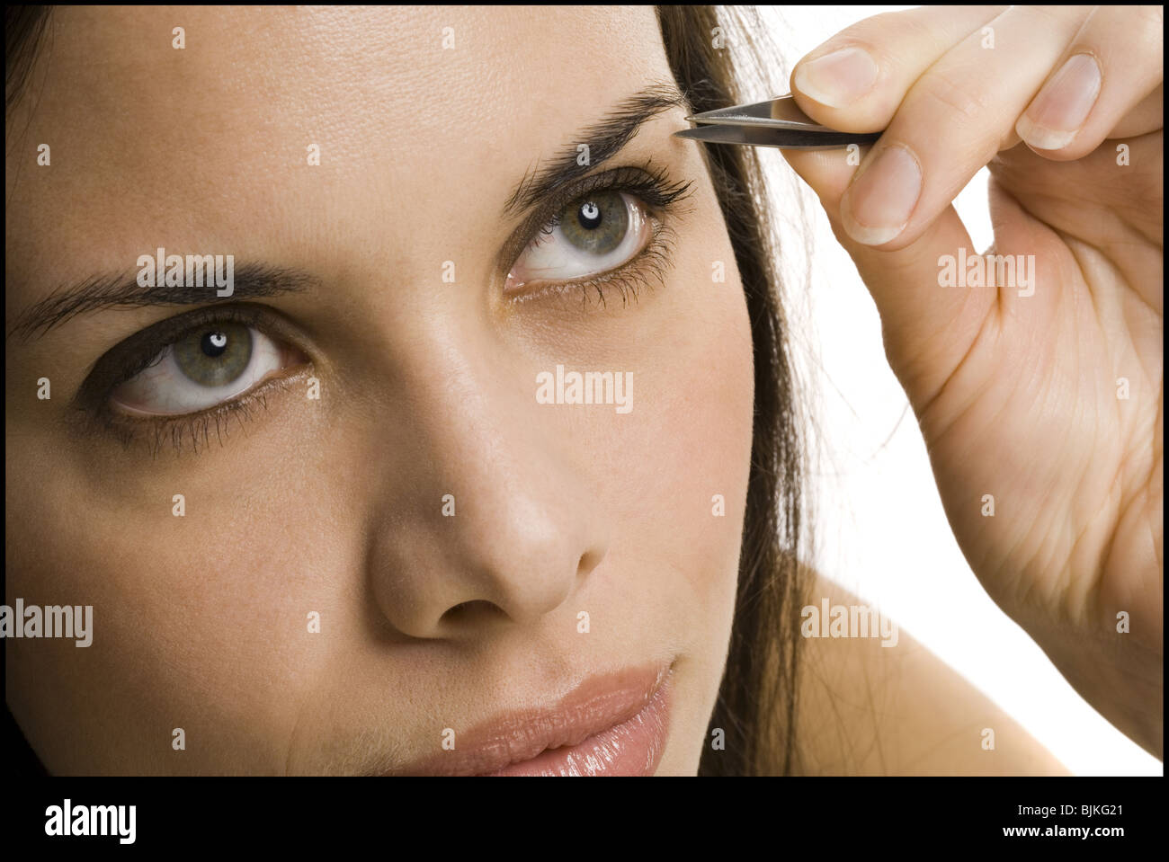Woman tweezing eyebrows Stock Photo - Alamy