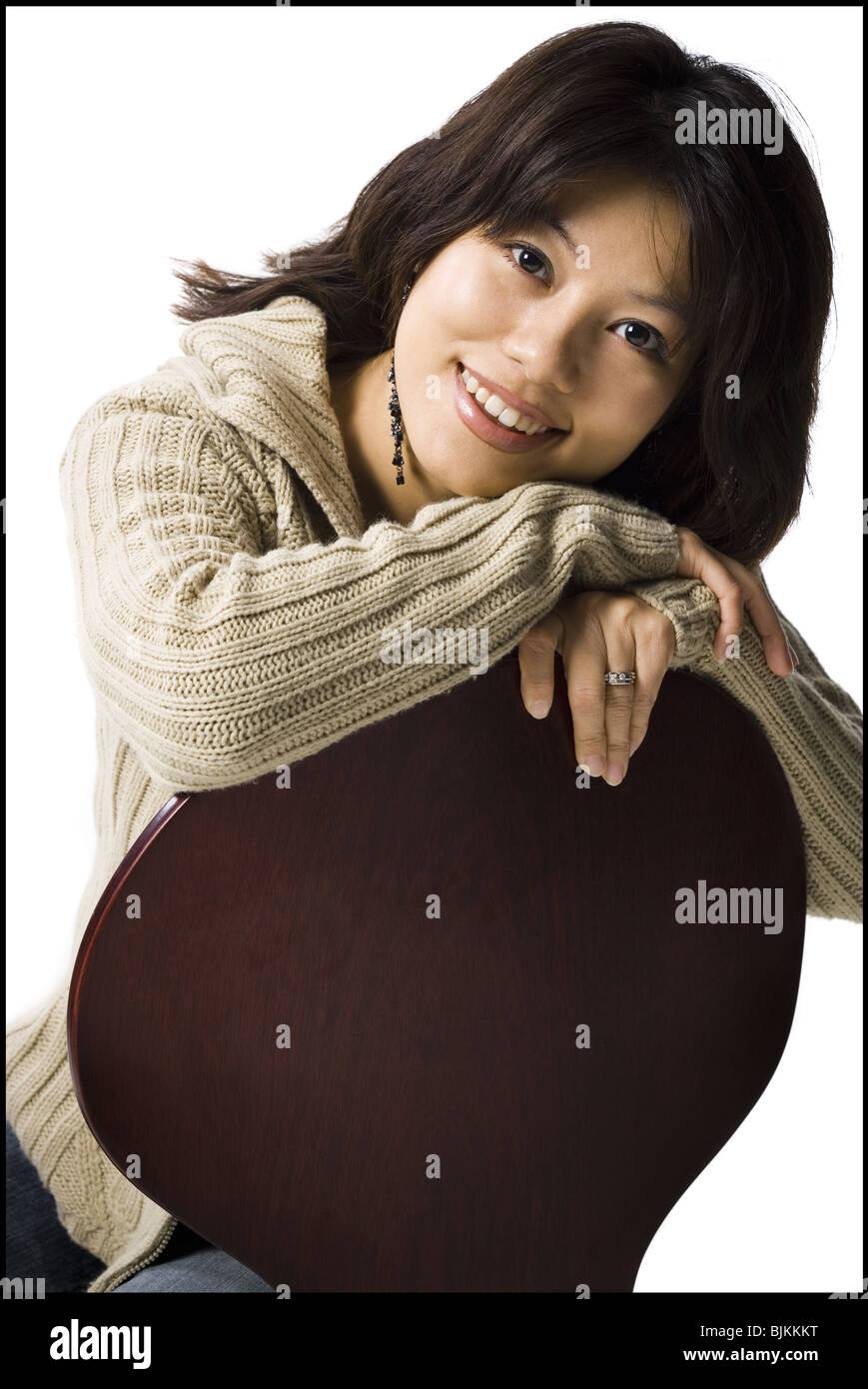 Woman sitting on chair smiling Stock Photo - Alamy
