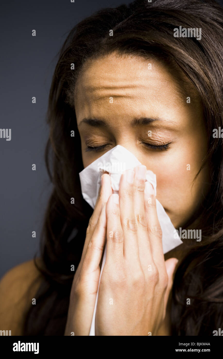 Woman with eyes closed blowing nose Stock Photo - Alamy