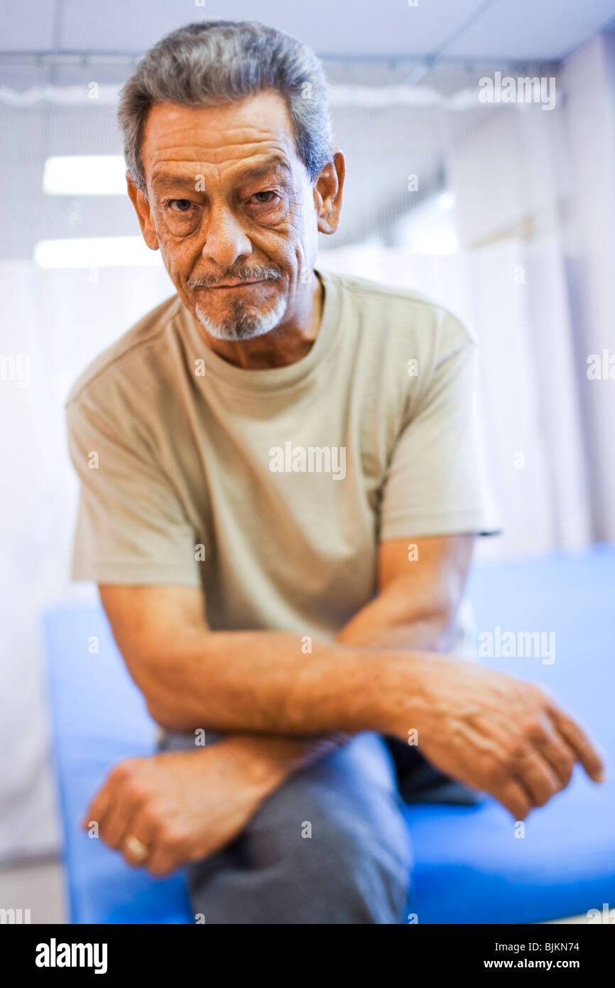 Man with one leg sitting with arms crossed smiling Stock Photo - Alamy