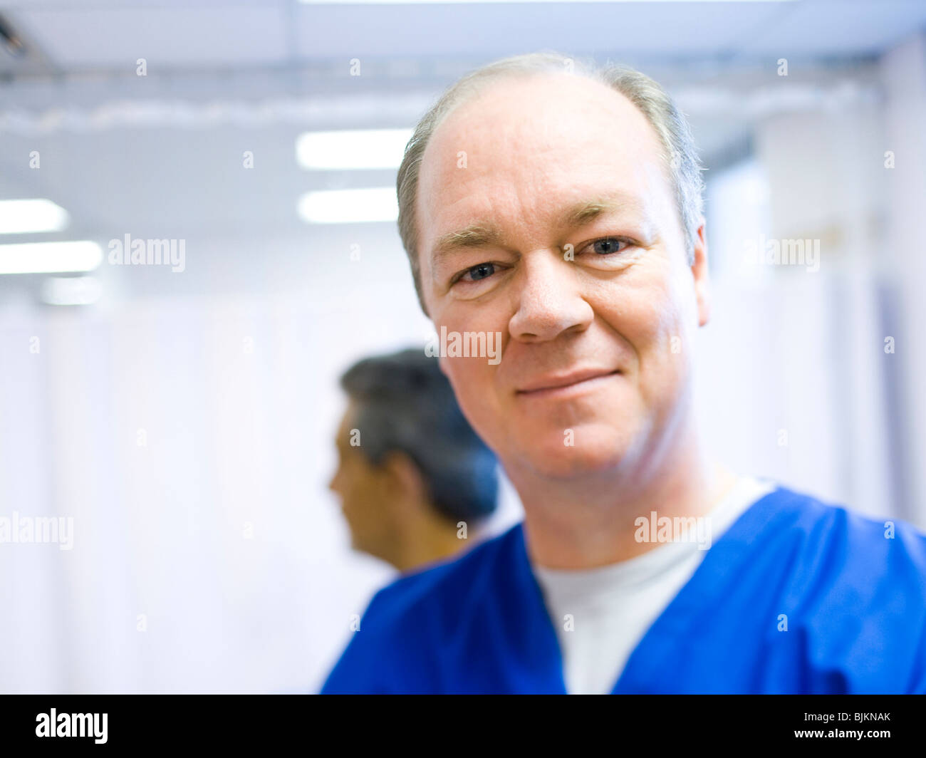 Male health care worker standing with arms crossed Stock Photo - Alamy