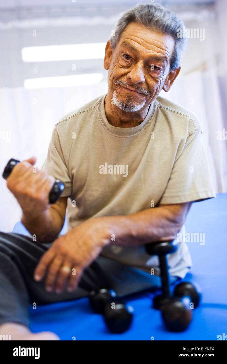 Man with one leg sitting and exercising with weights Stock Photo - Alamy