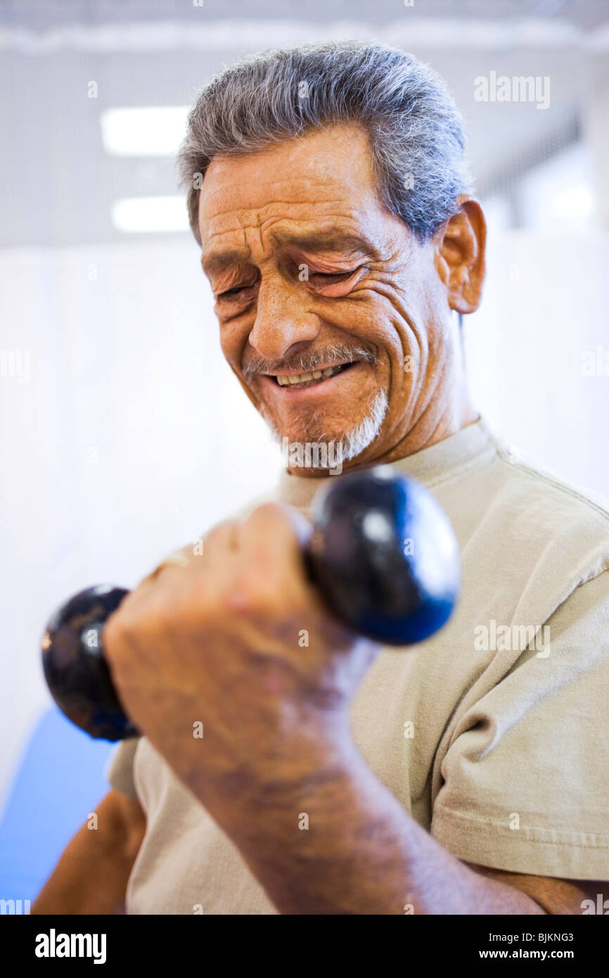 Man with one leg sitting and exercising with weights Stock Photo - Alamy