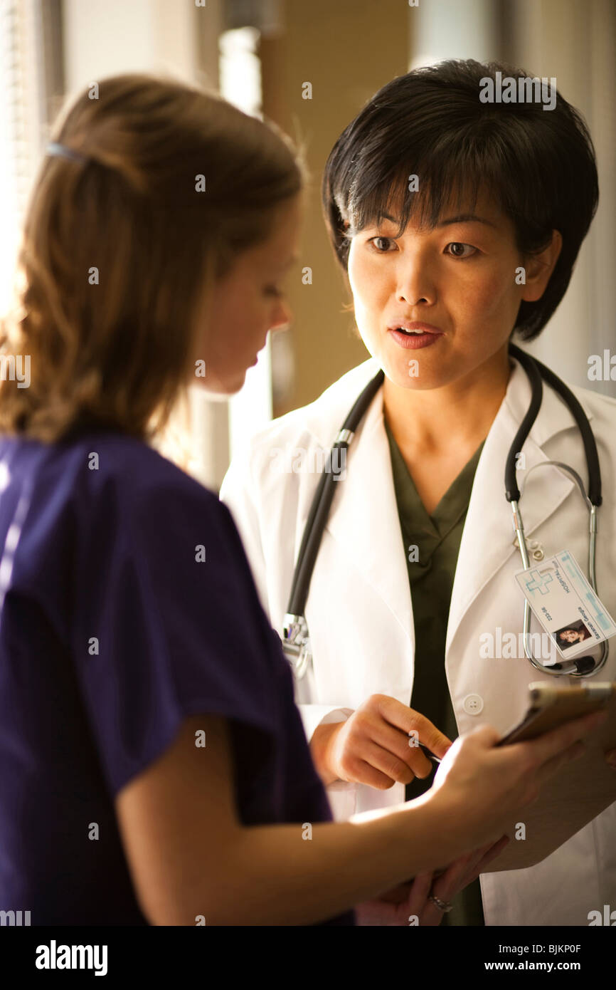 Female doctor talking to nurse Stock Photo - Alamy