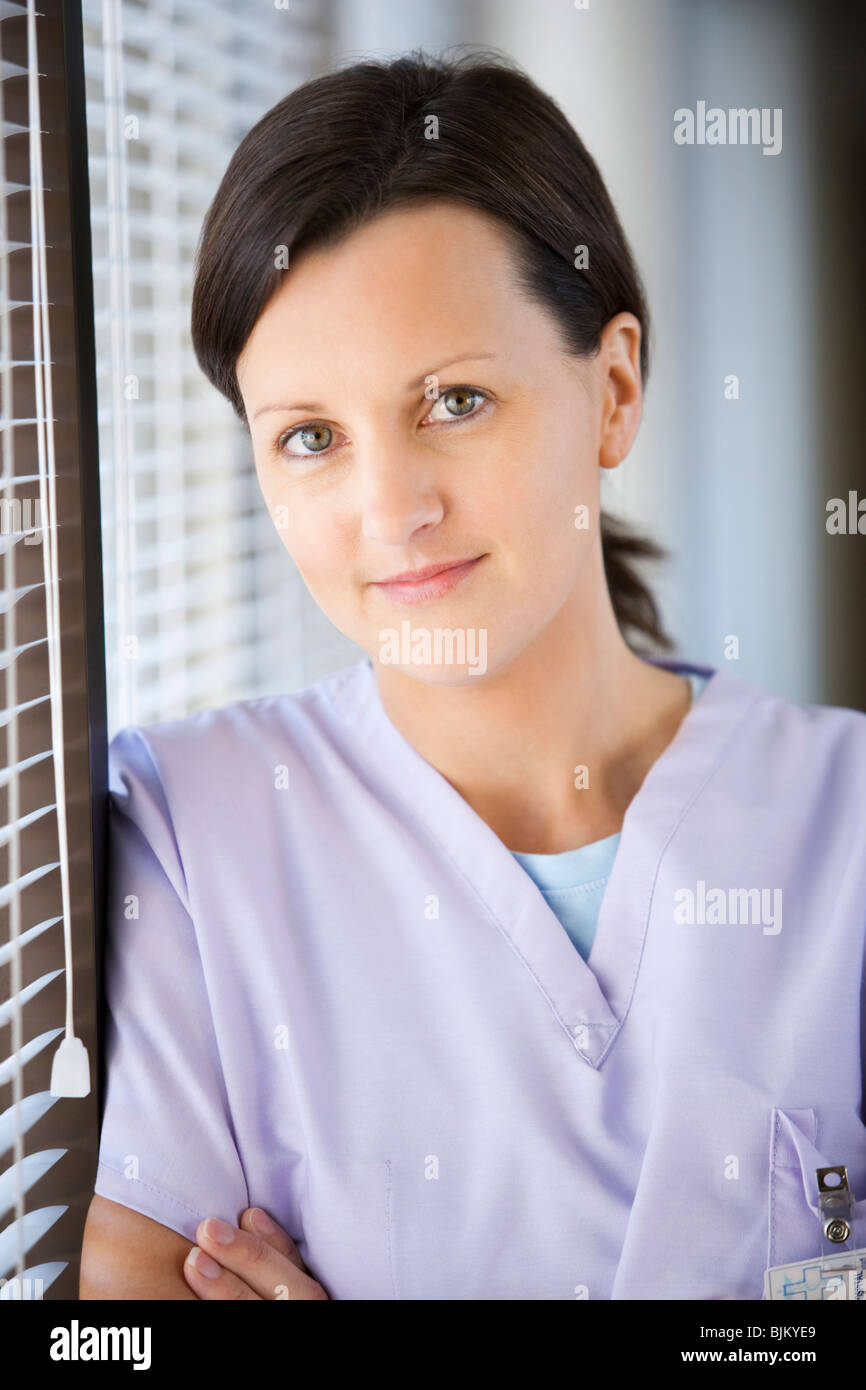 Female nurse leaning on blinds Stock Photo - Alamy