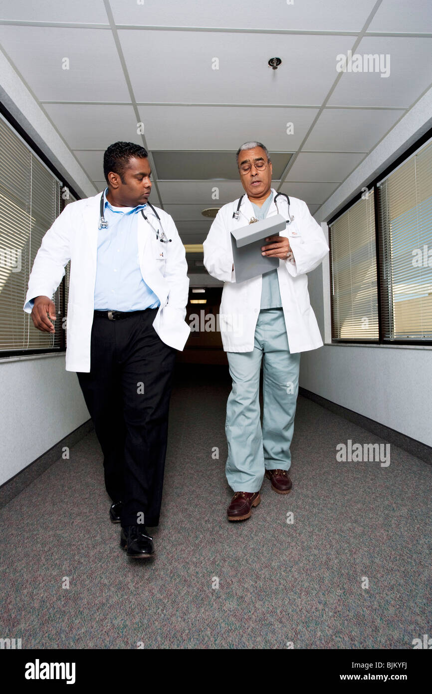 Male doctors walking and talking Stock Photo - Alamy