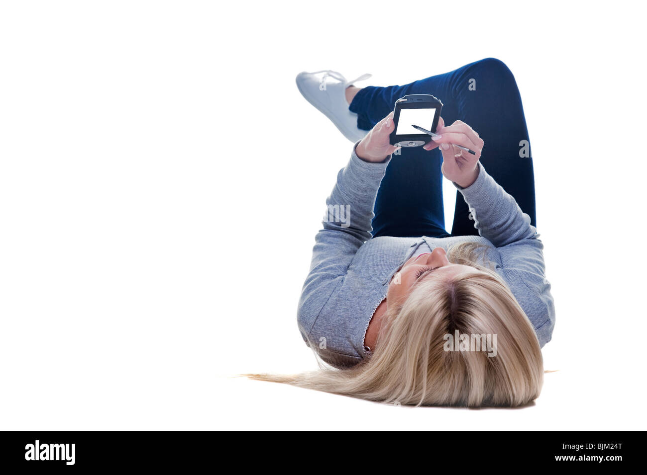 Woman lying down writing on her pda isolated on a white background ...