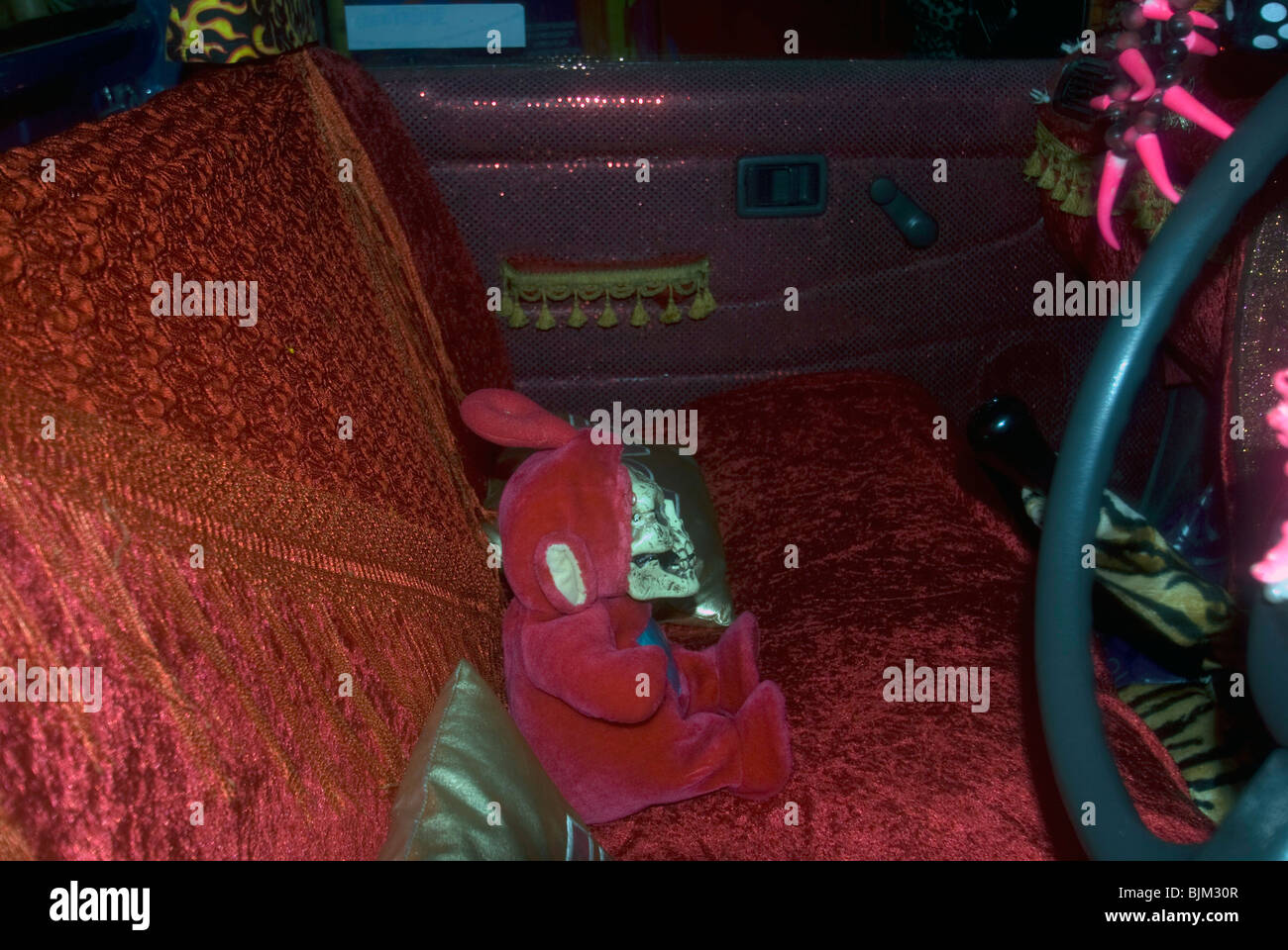Teletubby with skull face sitting on the seat of a car at the Art Car ...