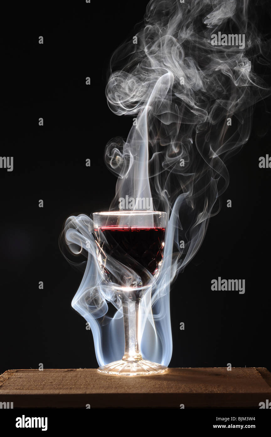 A glass of smoky red wine with black background Stock Photo - Alamy
