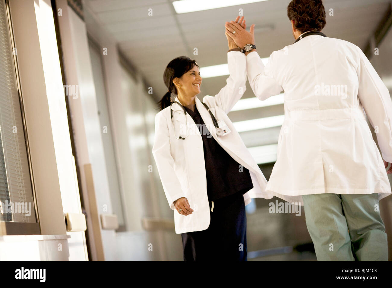 Female and male doctor giving high-five Stock Photo - Alamy